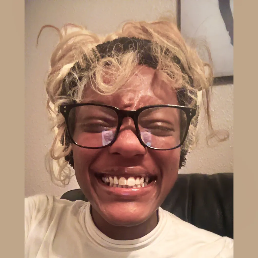 Tight close-up of Isata Siri laughing with eyes squinted, wearing ...
